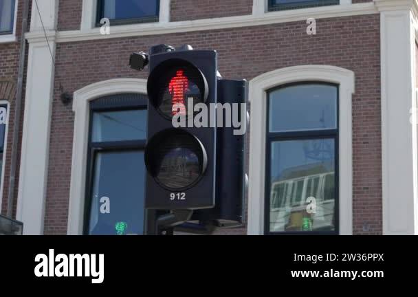 European pedestrian crosswalk sign. Traffic lights change from red to ...
