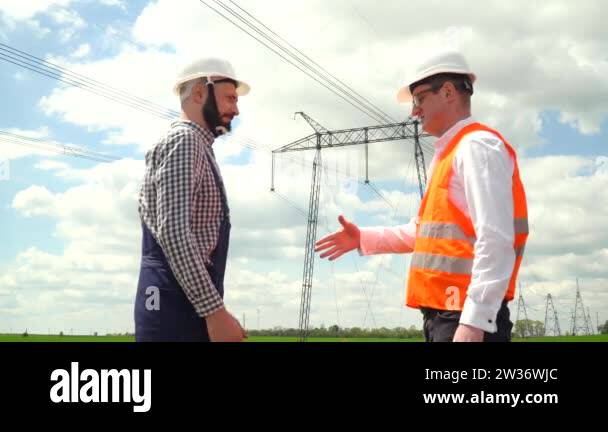Two engineers working near transmission lines. Energy cooperation ...