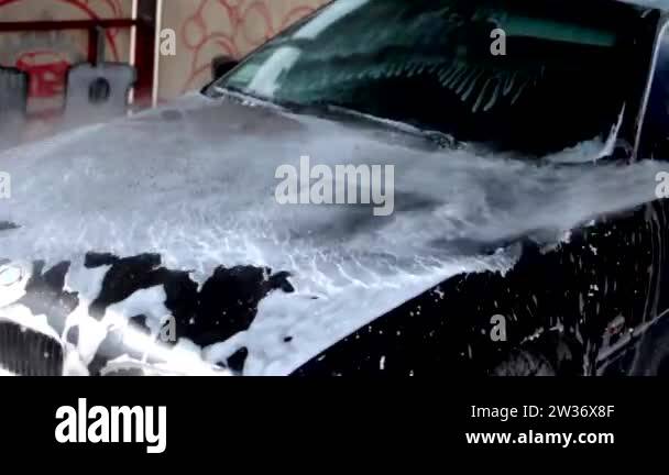 The process of washing a BMW business class car, rinsing the foam from ...