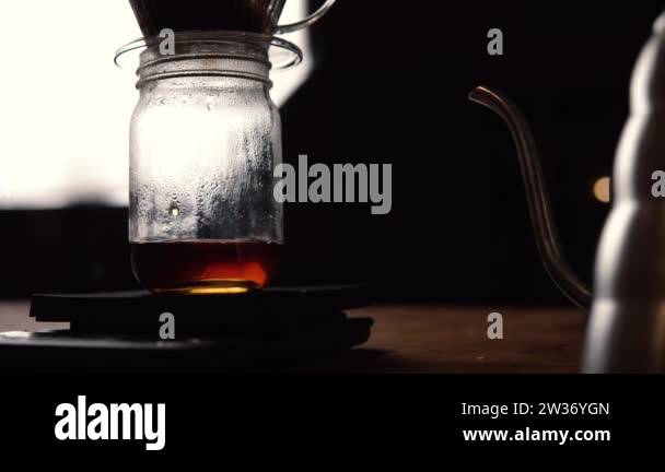 Coffee being brewed into a clear glass pot. A Dripping stream ripples ...