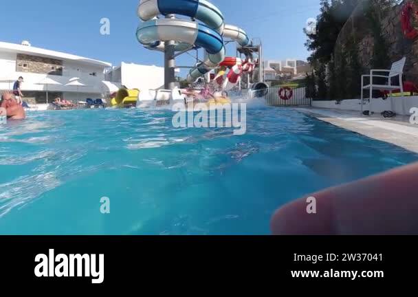 Mother and daughter having fun in aqua park. They are sliding down from ...