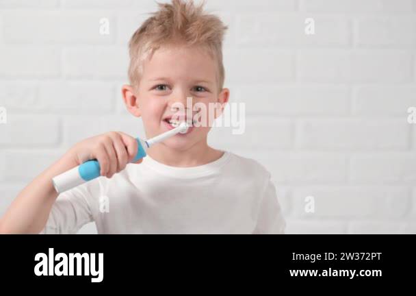 Portrait happy smiling child kid boy brushing teeth with electric ...