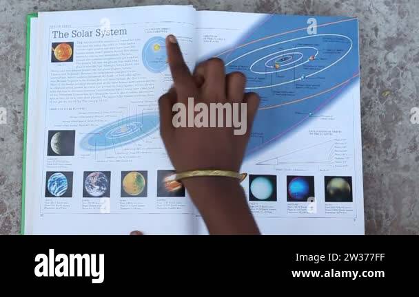 Girl child is reading a book in the Outdoor. Girl student sitting and ...