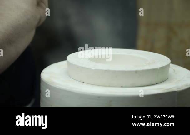 Woman`s hands put on a potter's wheel a form for a clay cup, throw a ...