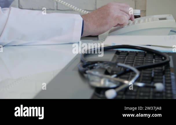 Doctor in Hospital Office Dialing a Phone Number Using a Landline ...