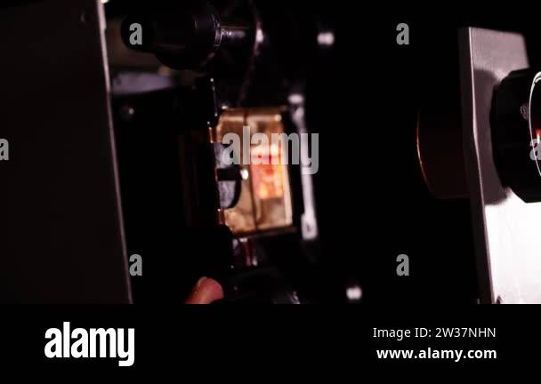 Macro view of vintage slide projector and fingers that are spinning a ...