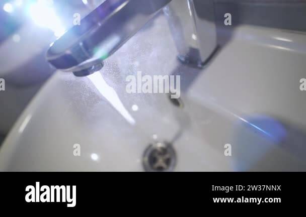 Hot tap water. Warm water flows from the tap in the bathroom ...