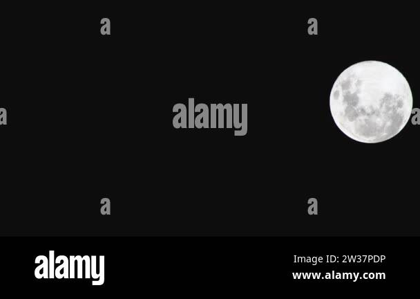 full moon in the night sky moving across the frame with camera panning ...