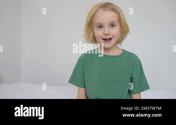 Boy shaking wobbly milk tooth in open mouth before it changes to the ...