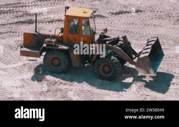 Old Tractor on Rubber Wheels Moves Sand Using a Bucket on Construction ...