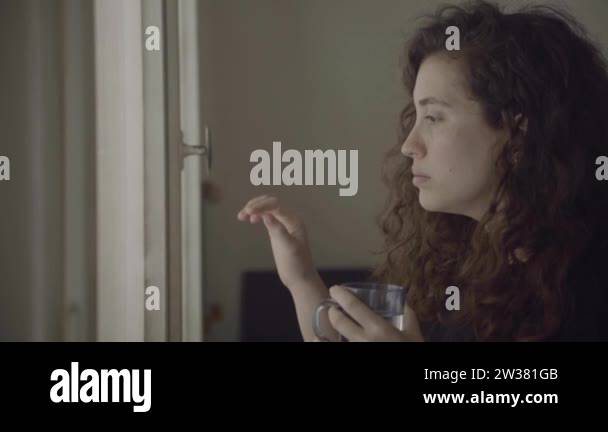 Woman stuck indoors with sad face puts hand on window glass Stock Video ...