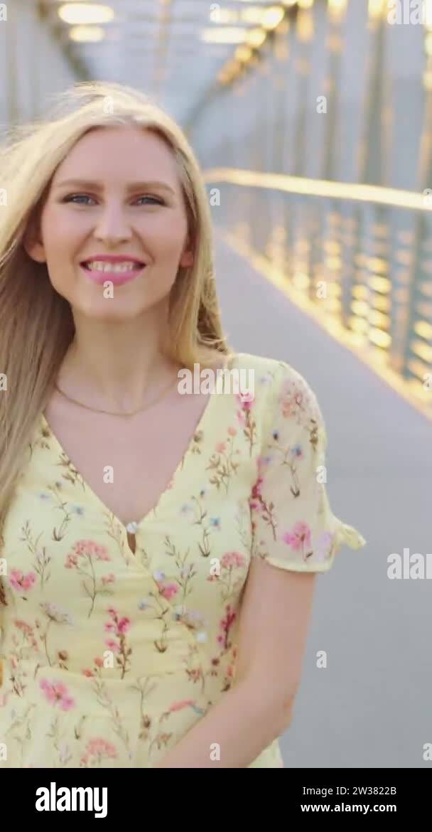 Woman looking back on bridge. Pretty blonde girl looking back at camera ...