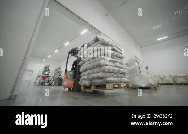 Warehousing. Forklift driver stacking big bag of raw material in ...