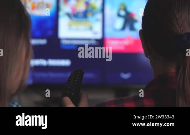 Woman hand selects internet tv channels with remote control, close-up ...