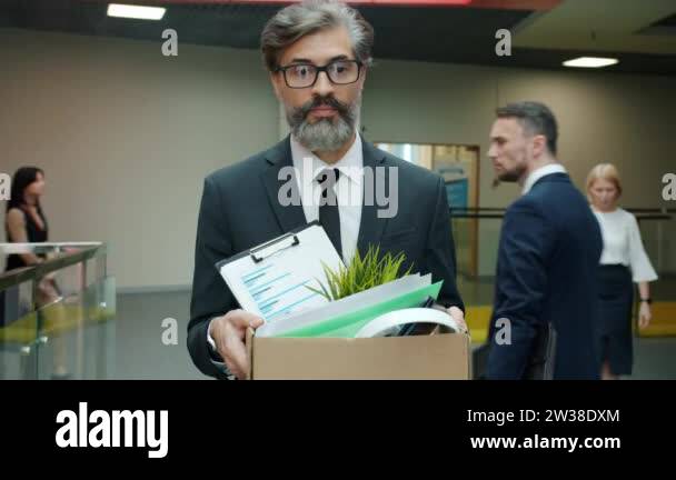 Sad office worker walking in hallway with carton box leaving work after ...