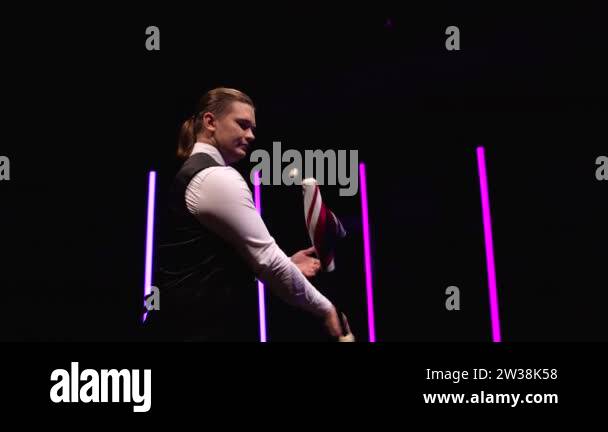 Camera rotates around professional circus performer juggling with clubs ...