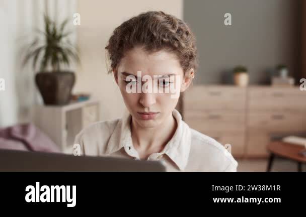 Medium close-up of young big-eyed Caucasian woman looking at invisible ...