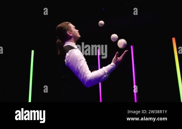 Orbital shot professional circus performer juggling with five white ...