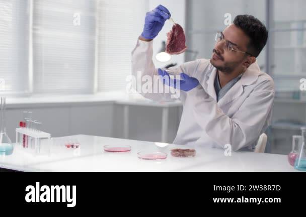 Medium slow-motion footage of male microbiology scientist doing ...