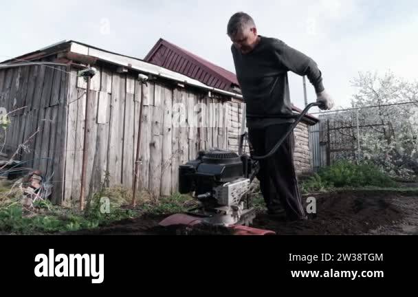 old man plowman plows the earth with a big effort motoblock. Very hard work Stock Video Footage ...