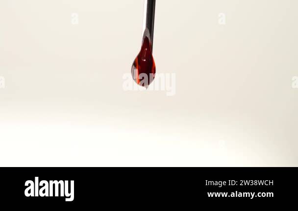 Drops of blood from the tip of the medical syringe. Bloody liquid ...