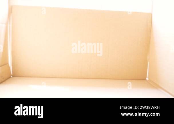 Small red-haired boy looking in parcel box with positive emotions and ...