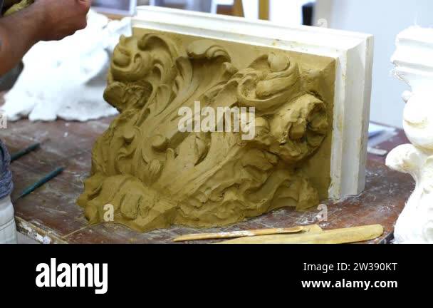 Sculptor create clay model of a Corinthian capitel with scrolls and ...