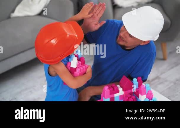 Construction worker father with his son wearing construction helmets ...