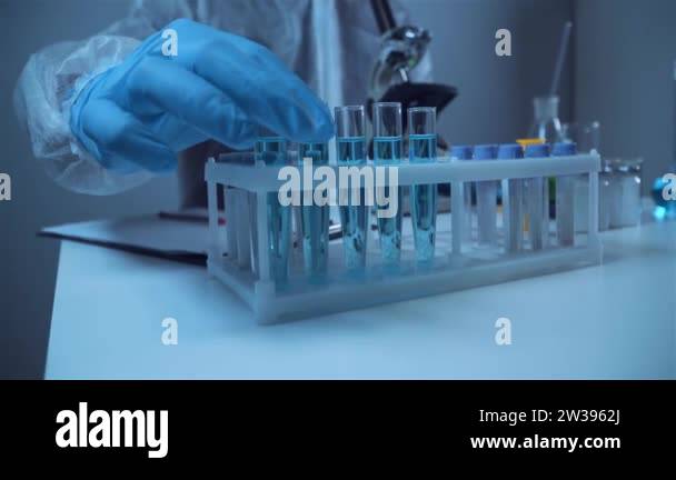 Biochemistry laboratory research, chemist in protective suit analyzing ...