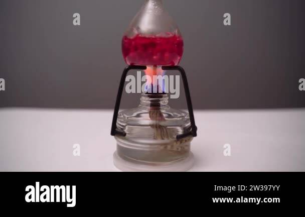 Close-up boiling liquid in a flask in the laboratory. Zoom in bunsen ...
