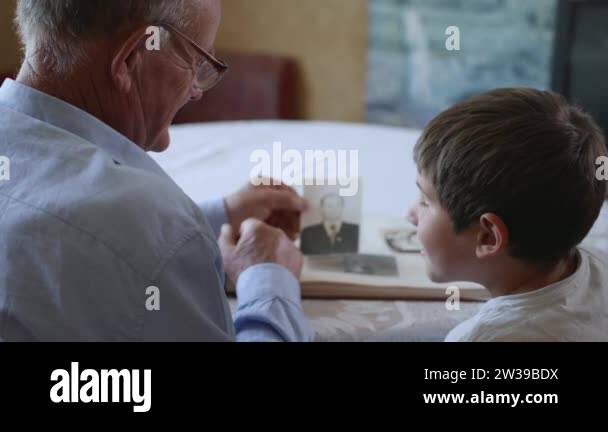 household, kind grandfather with his beloved grandchild shows photos of ...