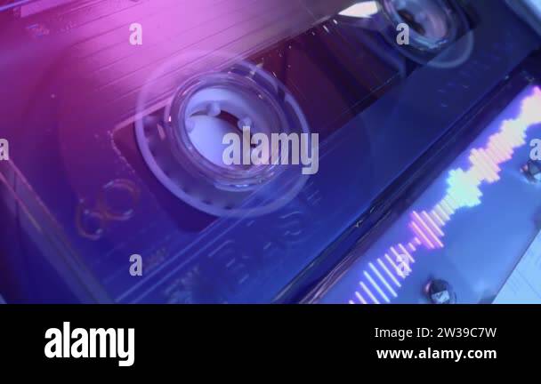 Rotating tape on an old vintage cassette. Retro music concept. Neon ...