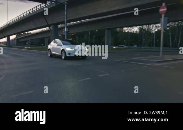 Modern Luxury White Electric Crossover Driving on Urban Road during ...