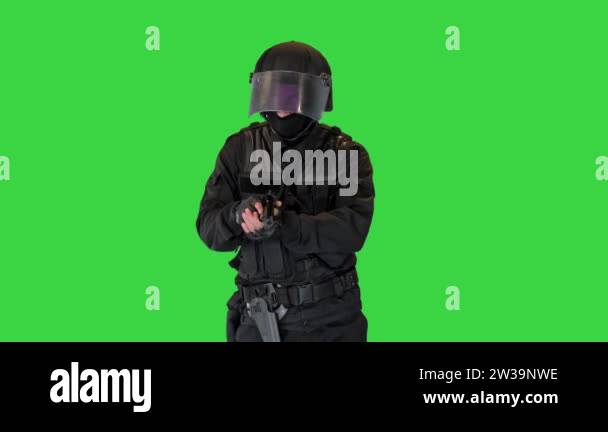 Anti terrorist or riot unit walking and aiming with a pistol on a Green ...