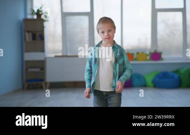 amusing little boy with down syndrome makes funny face at camera, child ...