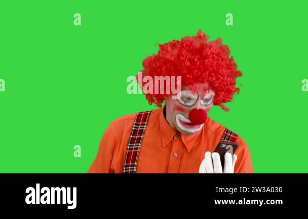 Clown with smartphone making a call on a Green Screen, Chroma Key Stock ...