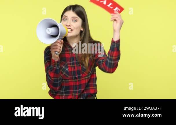 Female promoter in checkered shirt announcing great news in megaphone ...