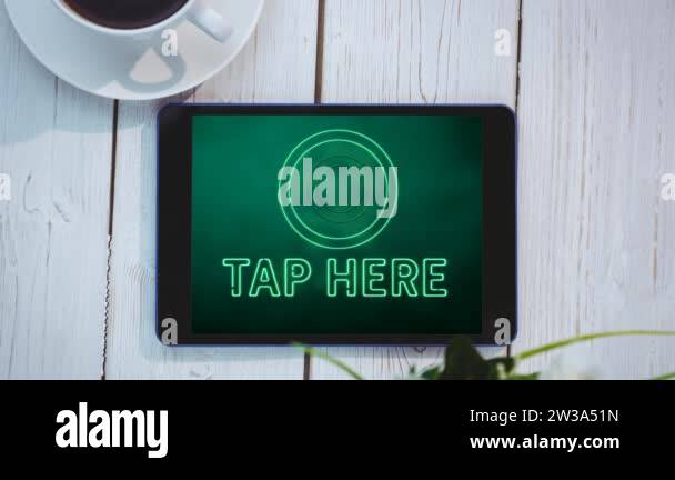 Animation of green neon style words Tap Here, flickering on screen of a ...