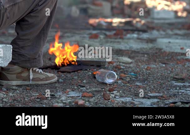 A Homeless Man Warms Himself up by the Fire. Close-up. Weak Heat From a ...