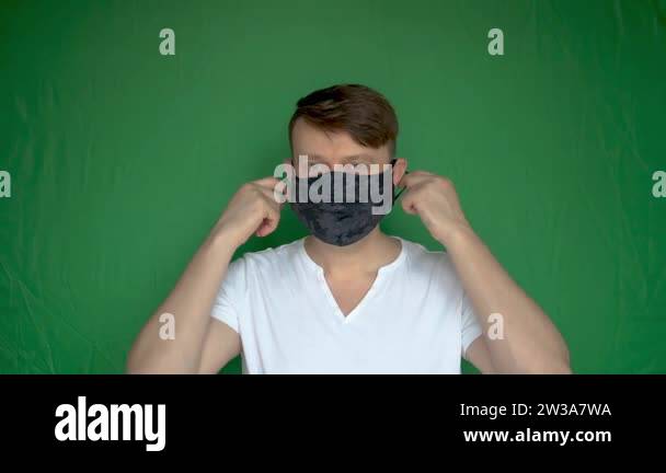 Satisfied fatigued man takes off the mask from his face and overjoyed ...