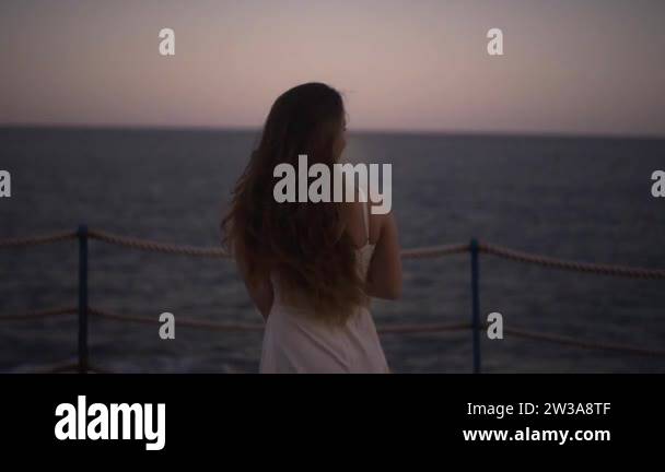 Girl smokes a vape on the background of the moon and the city of the ...