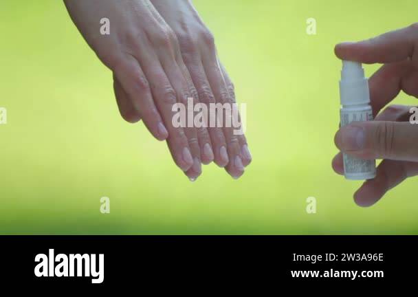 Spraying female hands with an antiseptic. Hand disinfection with an ...