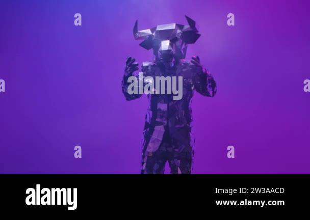 Shiny silver bull in costume made of mirrors dancing on neon blue pink ...