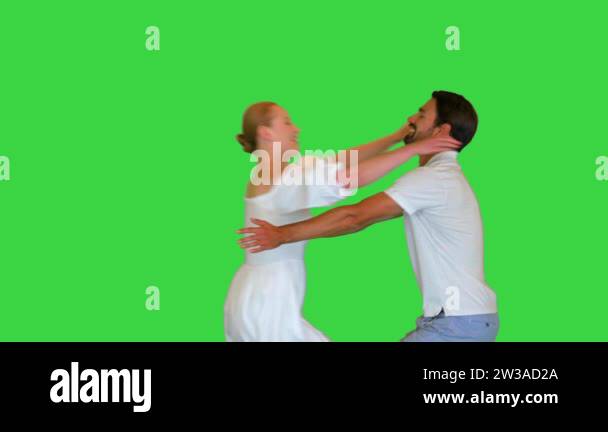Young couple is running to each other, hug and spin on a Green Screen ...