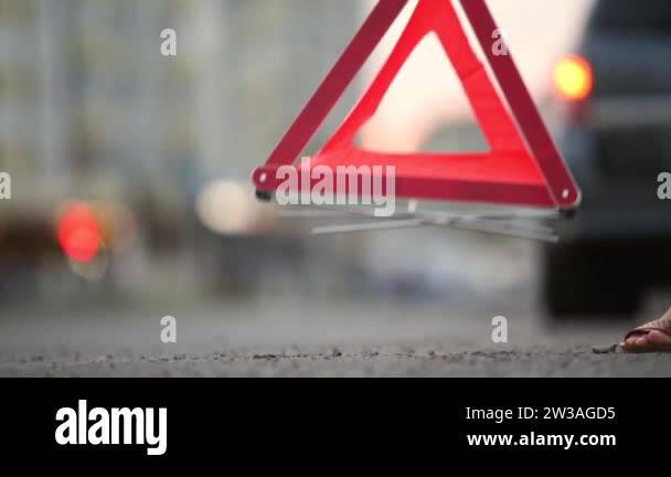 Woman driver putting an emergency stop sign behind broken blurred car ...