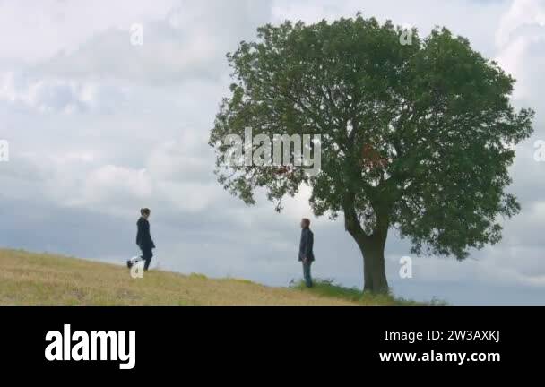 Young couple hugging and kissing under big green tree, eternal love ...