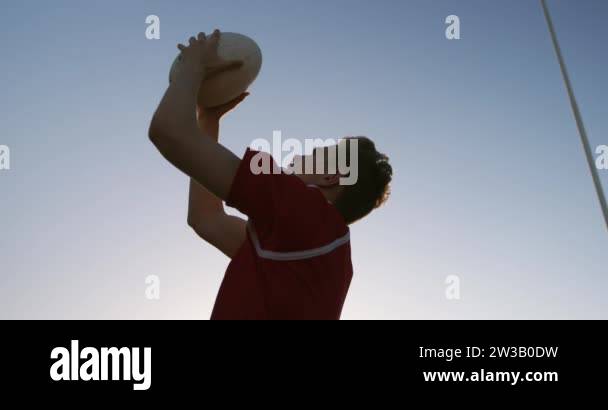 Low angle side view of a teenage Caucasian male rugby player wearing ...