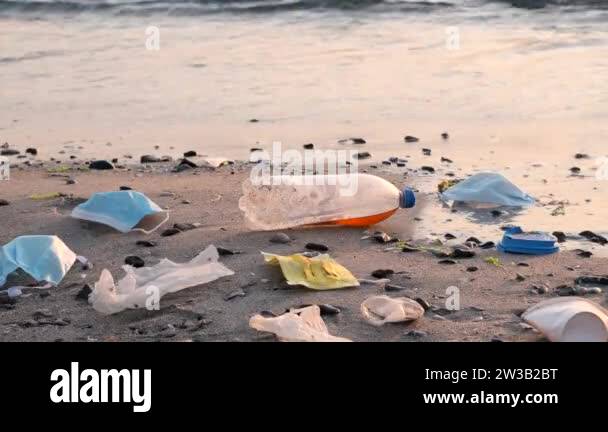 Disposable face masks and plastic debris on the beach in surf zone ...