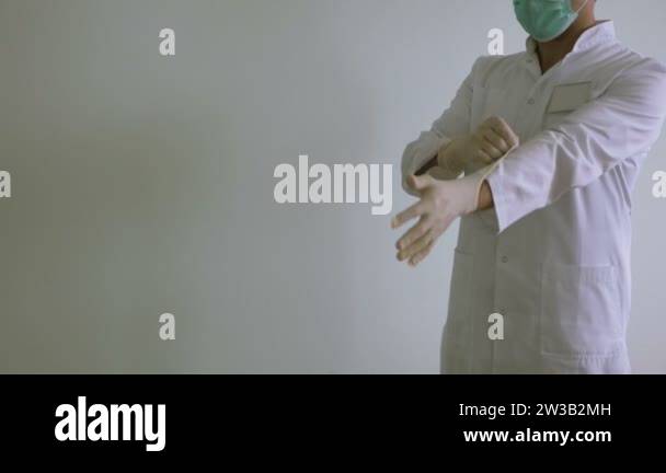 A Man Surgeon Puts On Sterile Gloves Preparing For A Medical Aid