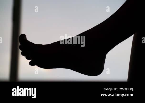 Silhouette of feet on window background. Landscape with rainy sky and ...